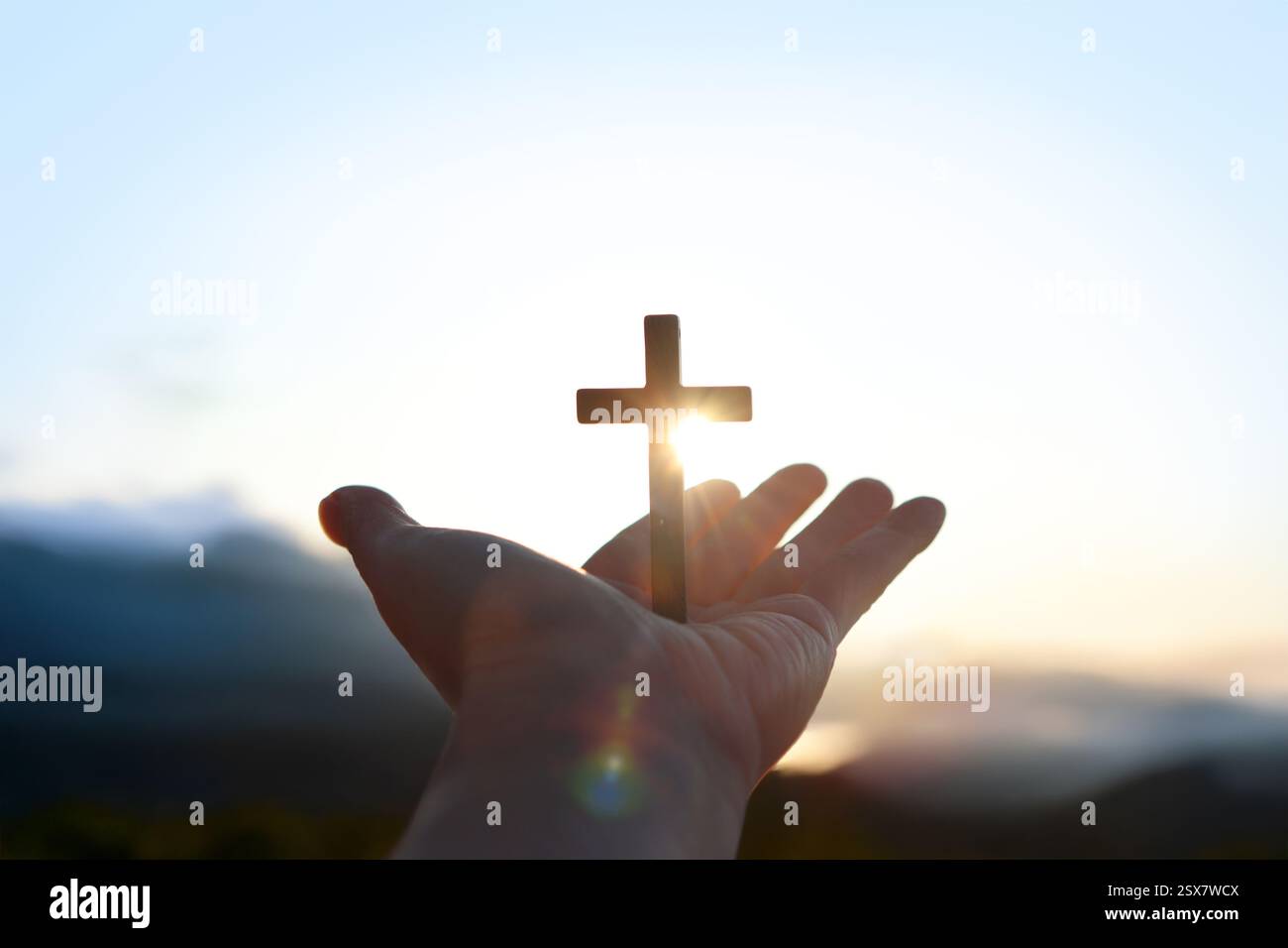 Christian's hands stretched out toward the rising sun, brilliant light ...