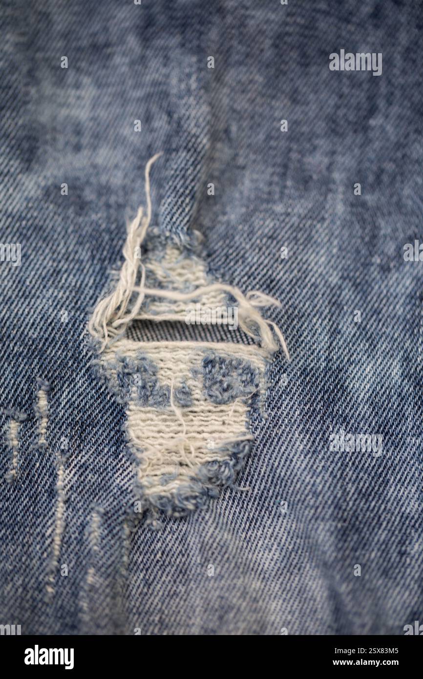 This unique denim piece features an impressive distress detail ...