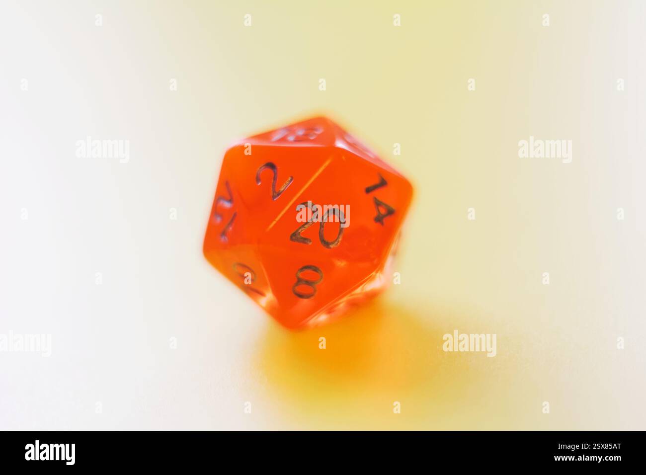 Orange dice showing face of 20 Stock Photo - Alamy