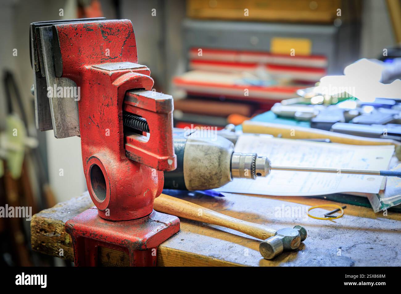 Inside a California gunsmith shop: a worn red vise stands on a ...