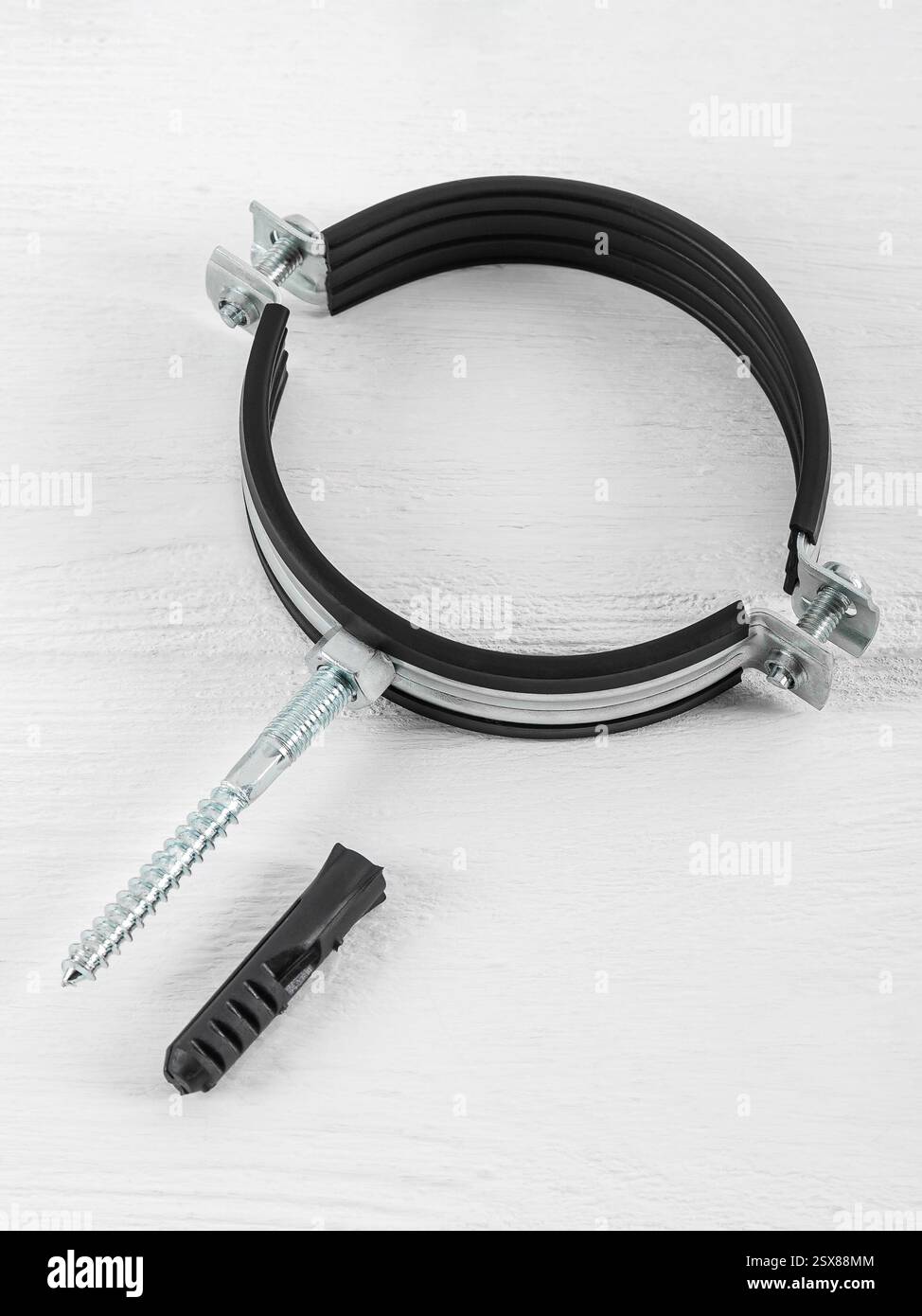 Clamp with a rubber gasket and fasteners on a white wooden background ...