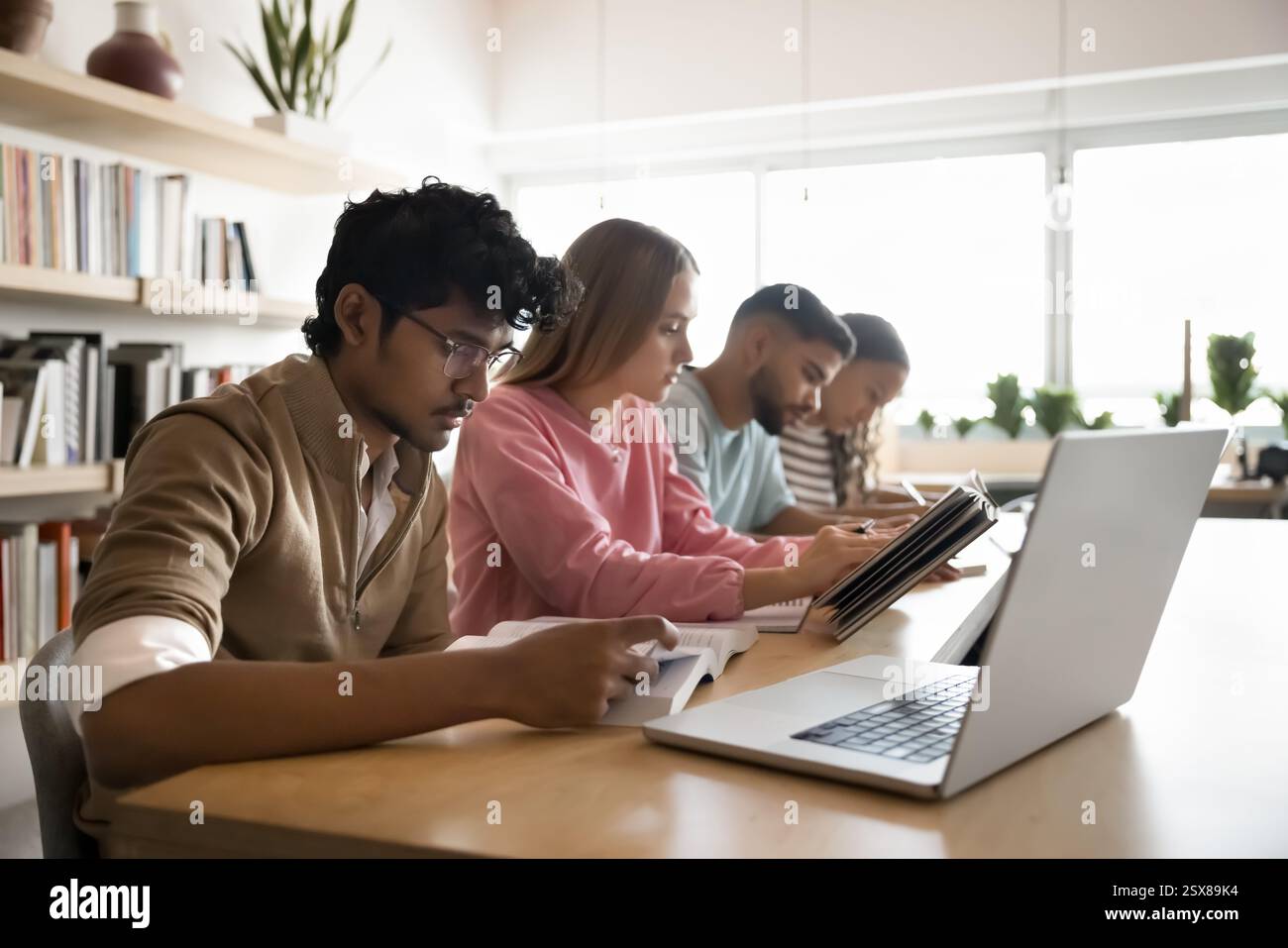 Serious students studying seated at table in library or classroom Stock ...