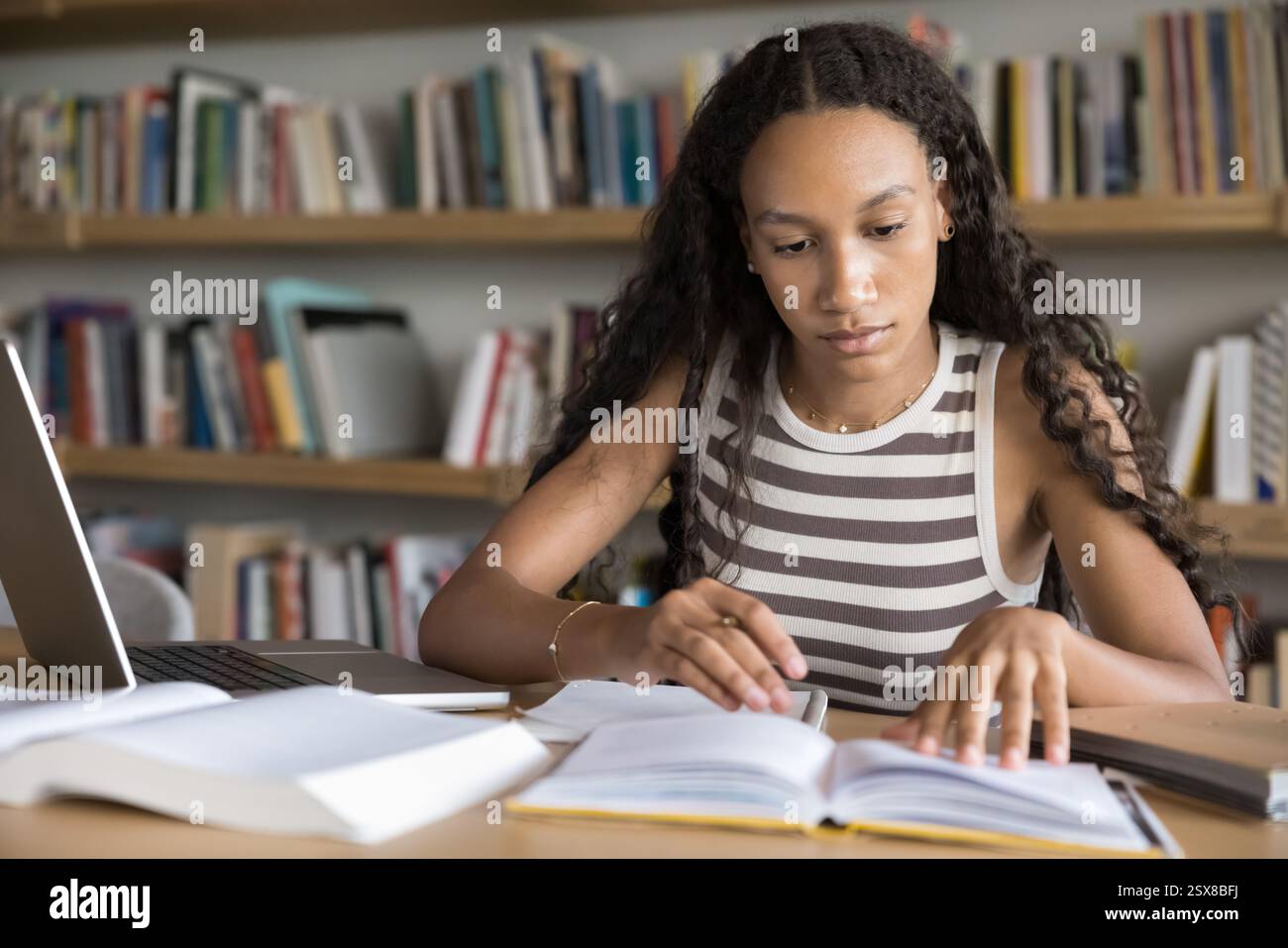 Focused African girl studying in college library Stock Photo - Alamy