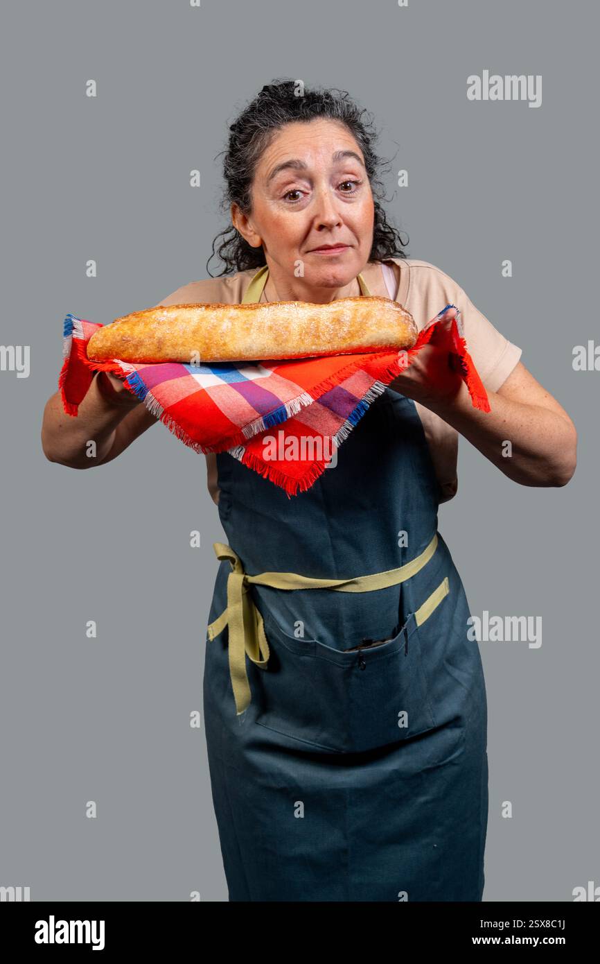 Baker woman proudly presenting a freshly baked loaf of bread, holding ...