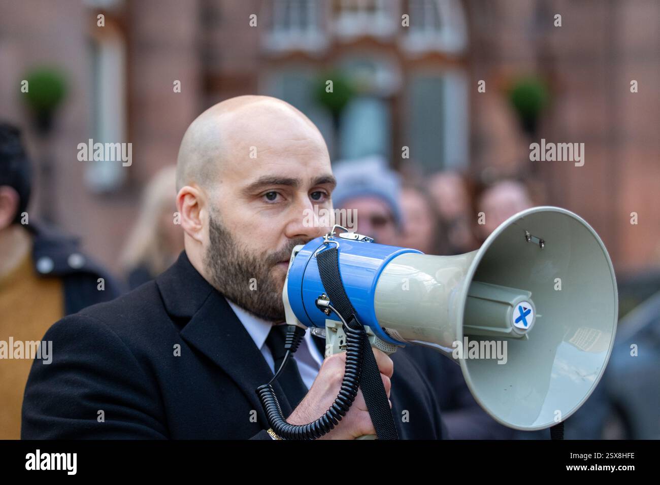 Nick Tenconi gives a speech to supporters before marching with a raised ...