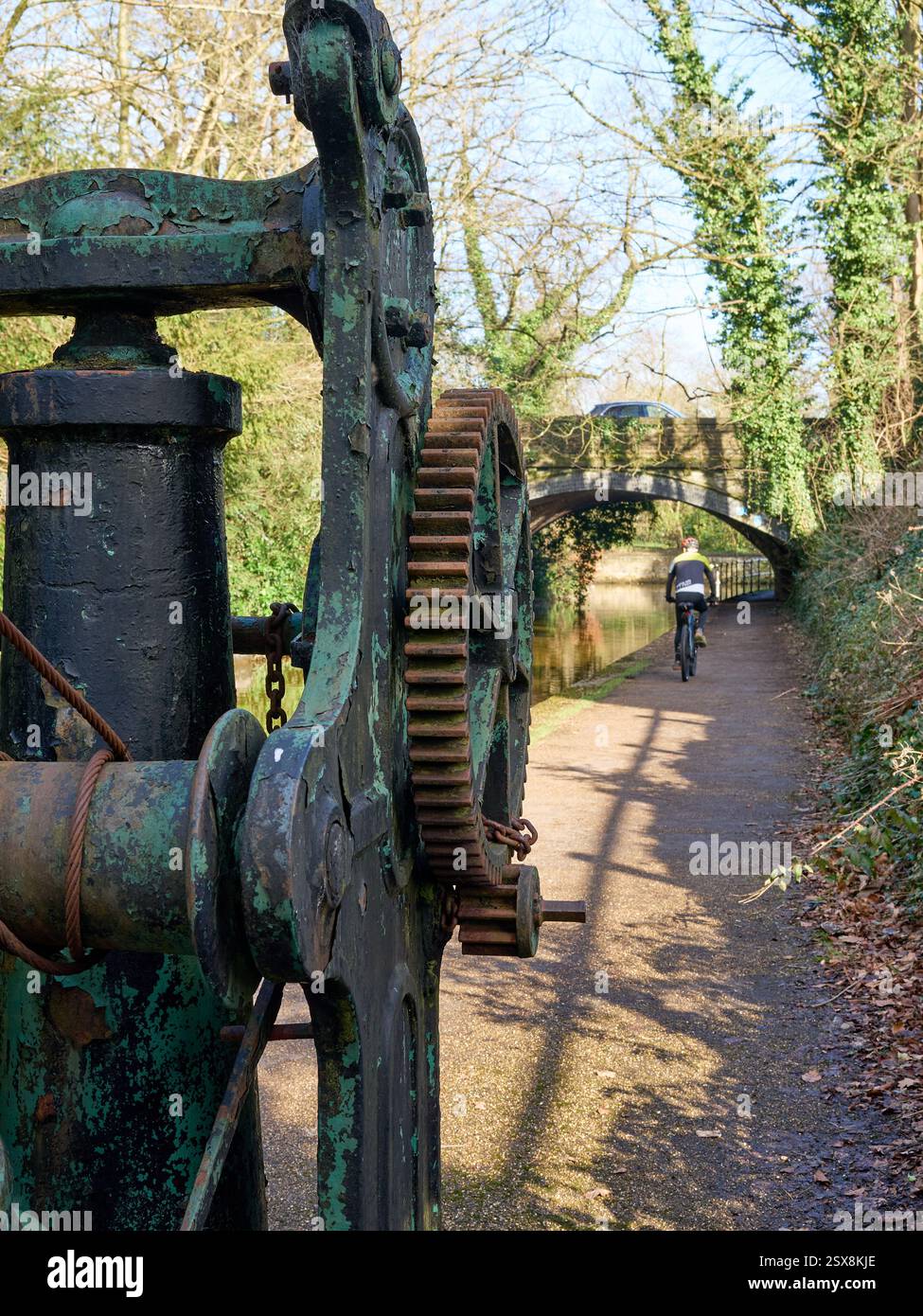 Bicyclist rides along scenic canal tow path beside historic iron ...