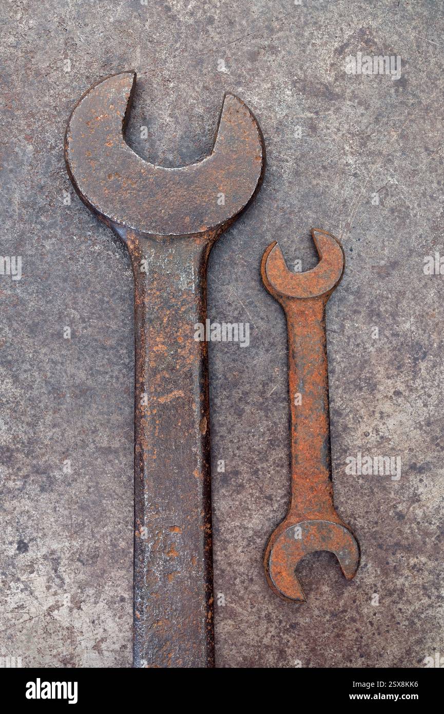 One large and one small rusty spanners lying on tarnished metal Stock ...