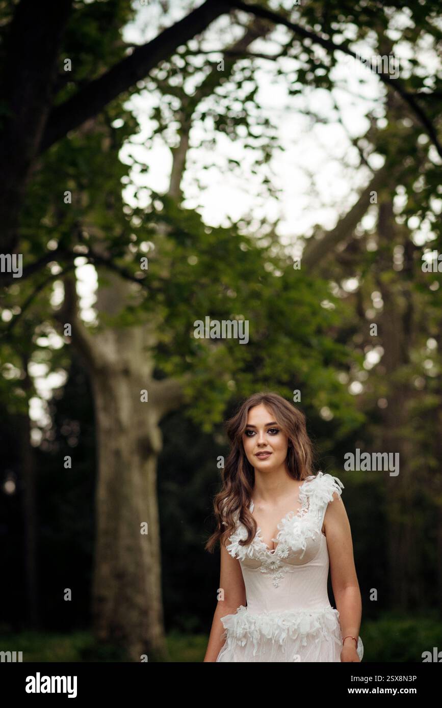 Stunning bride gracefully poses in a spring park, among blossoming ...