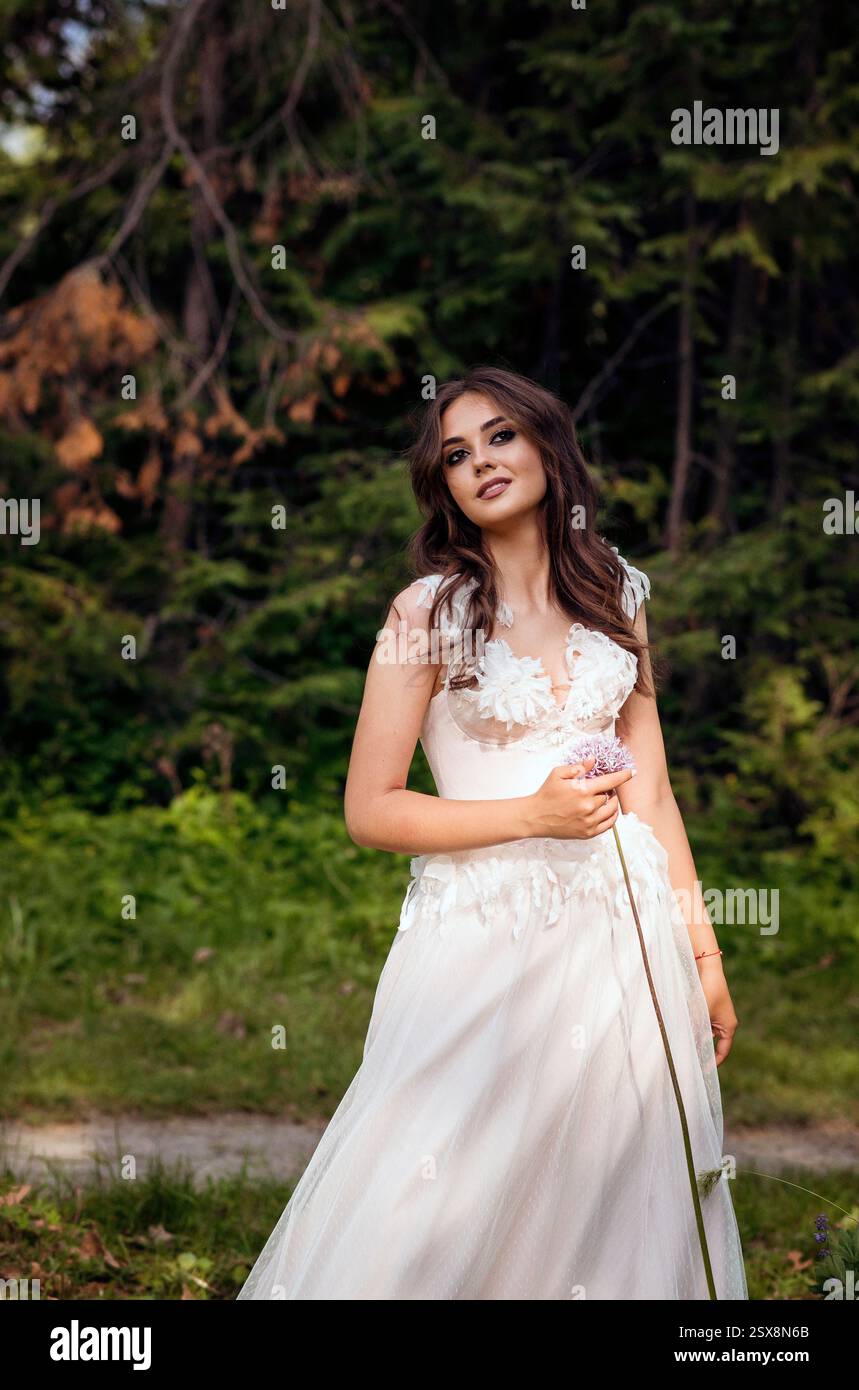 Stunning bride gracefully poses in a spring park, among blossoming ...