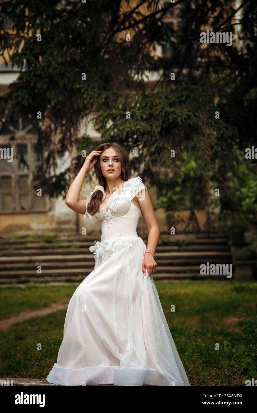 Stunning bride gracefully poses in a spring park, among blossoming ...