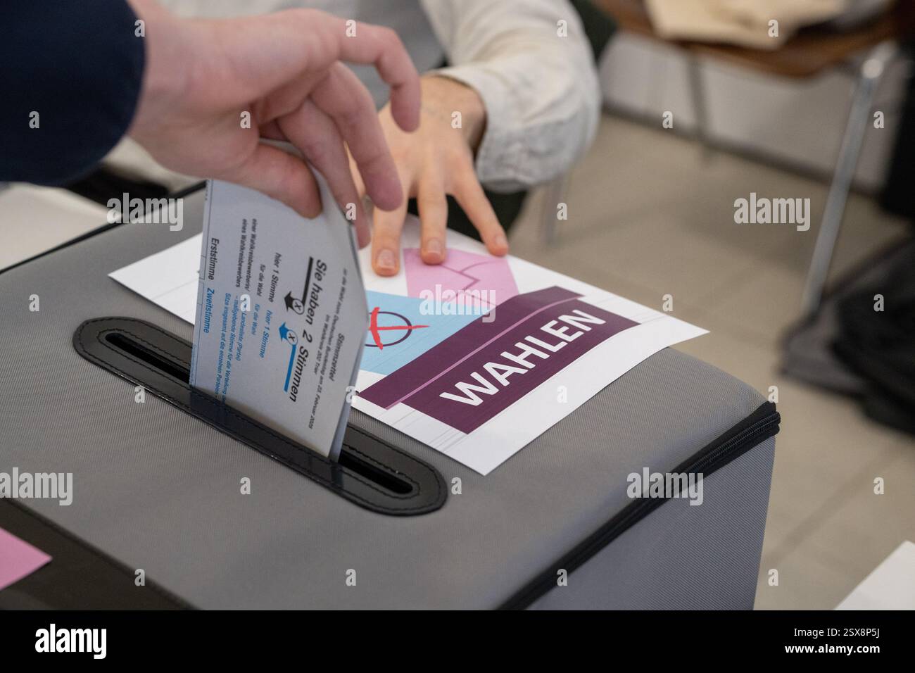 Kordel, Deutschland. 23rd Feb, 2025. A person slides the ballot paper ...