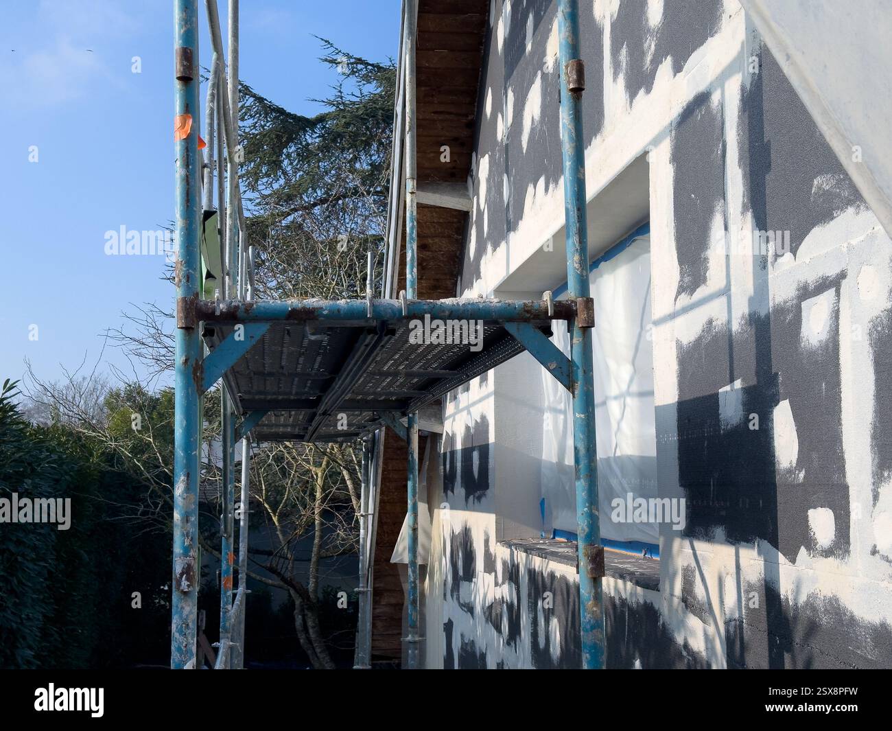 Scaffolding stands ready for a fresh coat on a house renovation project ...