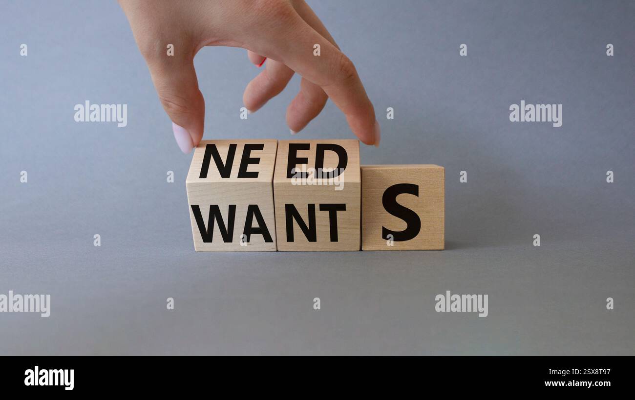 Needs and Wants symbol. Businessman Hand turns cubes and changes word ...