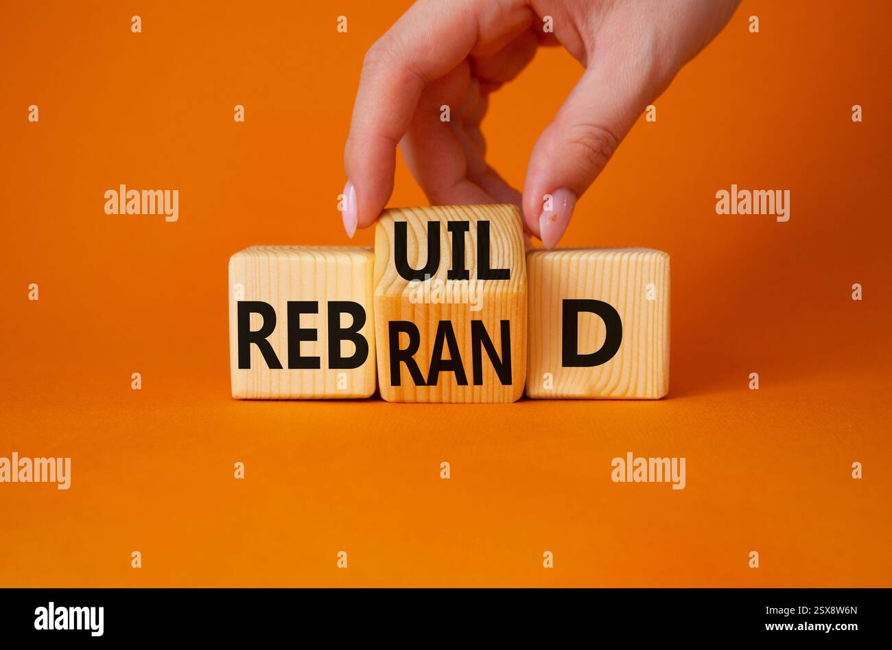 Rebuild and Rebrand symbol. Businessman hand turns wooden cubes and ...