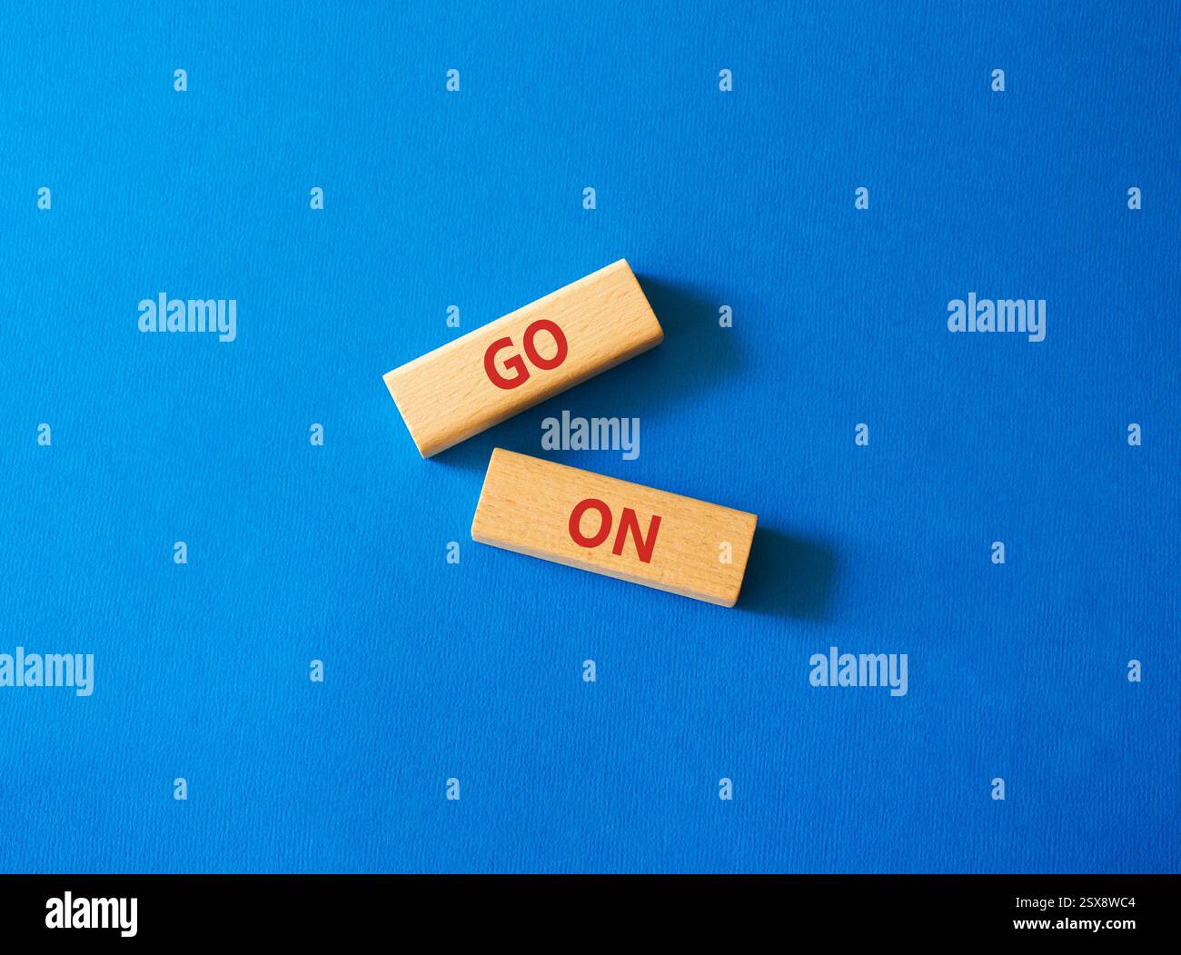 Go on symbol. Wooden blocks with words Go on. Beautiful blue background ...