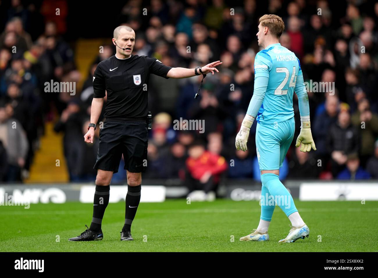 Referee Andrew Kitchen speaks to Luton Town goalkeeper Thomas Kaminski ...