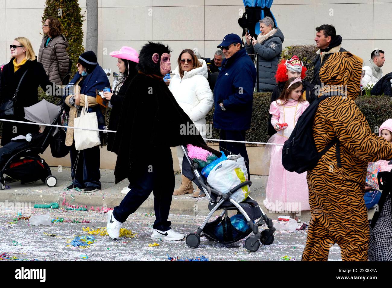 A woman wearing carnival costume pushes a baby stroller as she takes ...
