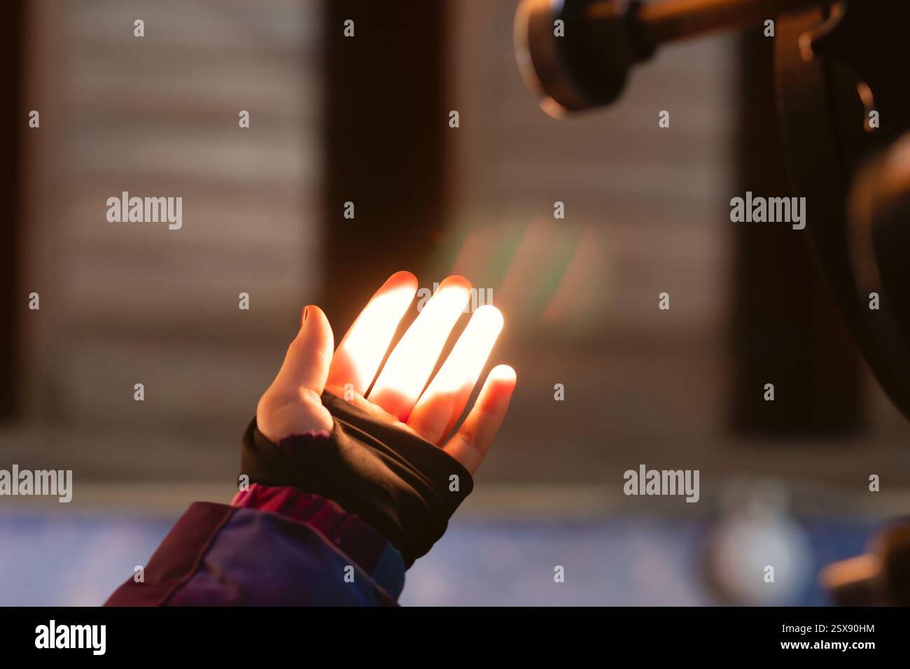 Hand illuminated by telescope light in dark observatory. The projection ...