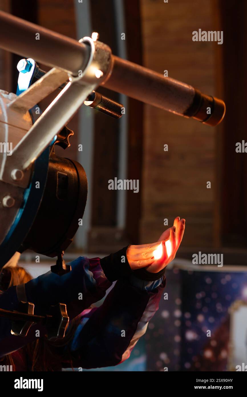 Gloved hand catching bright telescope light in an observatory. The ...
