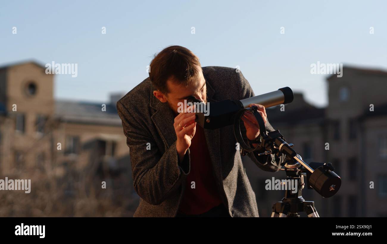 Man in grey coat carefully aligns telescope for solar observation Stock ...