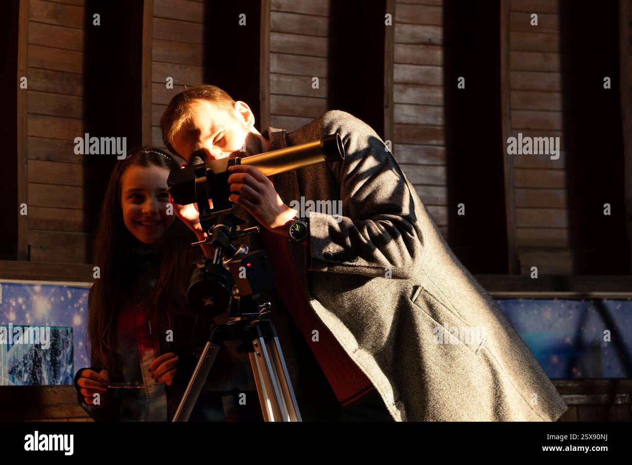 Man and girl enjoy solar telescope observation together in warm light ...
