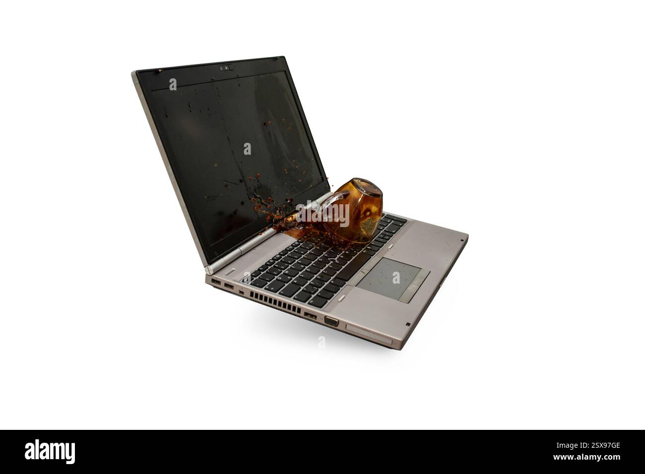 Coffee cup spilling and splashing on laptop keyboard isolated on white ...