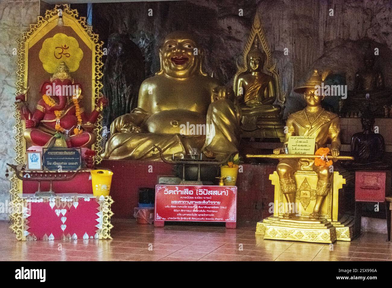 Golden statues of Buddha, Ganesha, and revered figures inside a sacred ...
