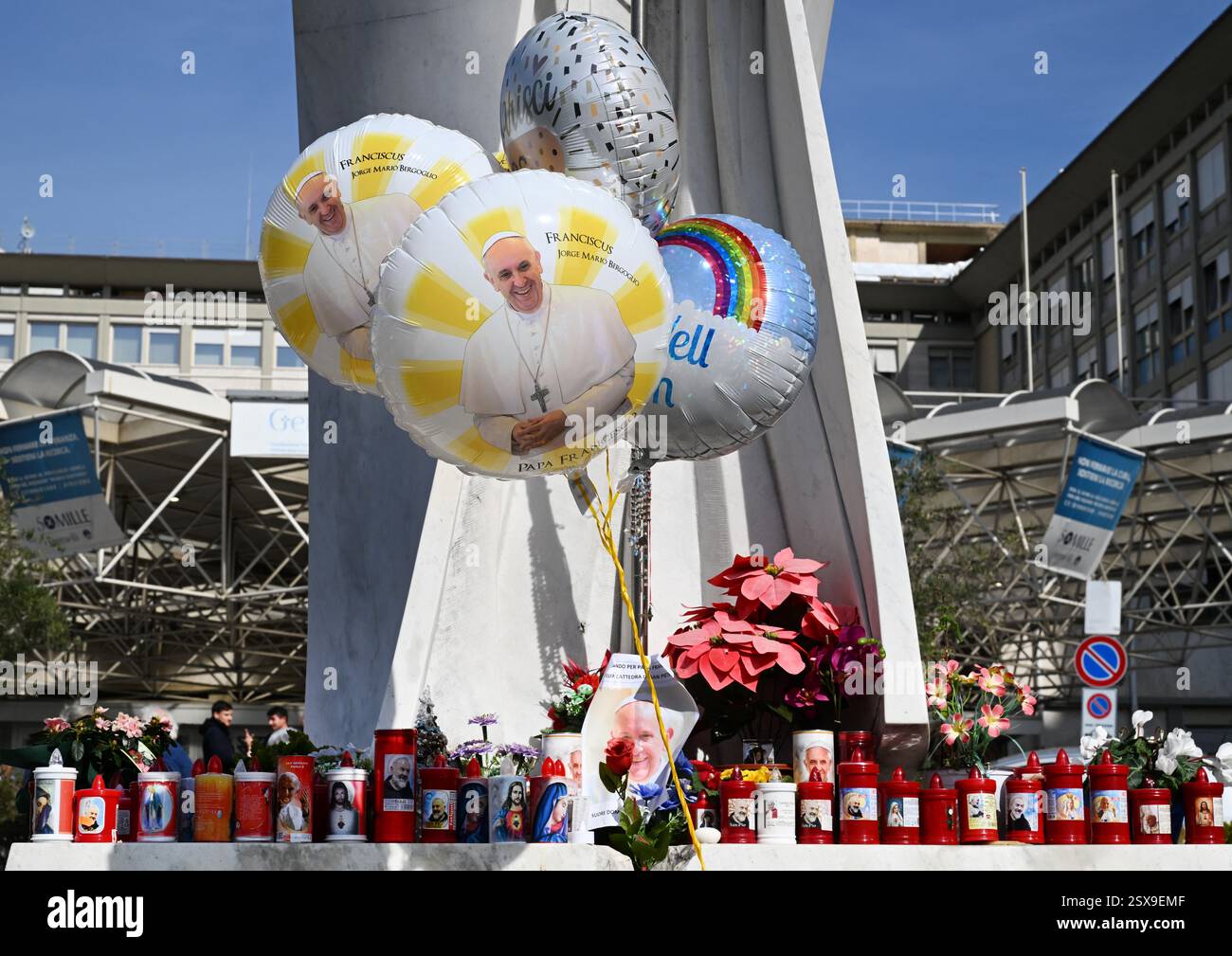 People pray near the statue of John Paul II outside the Gemelli ...