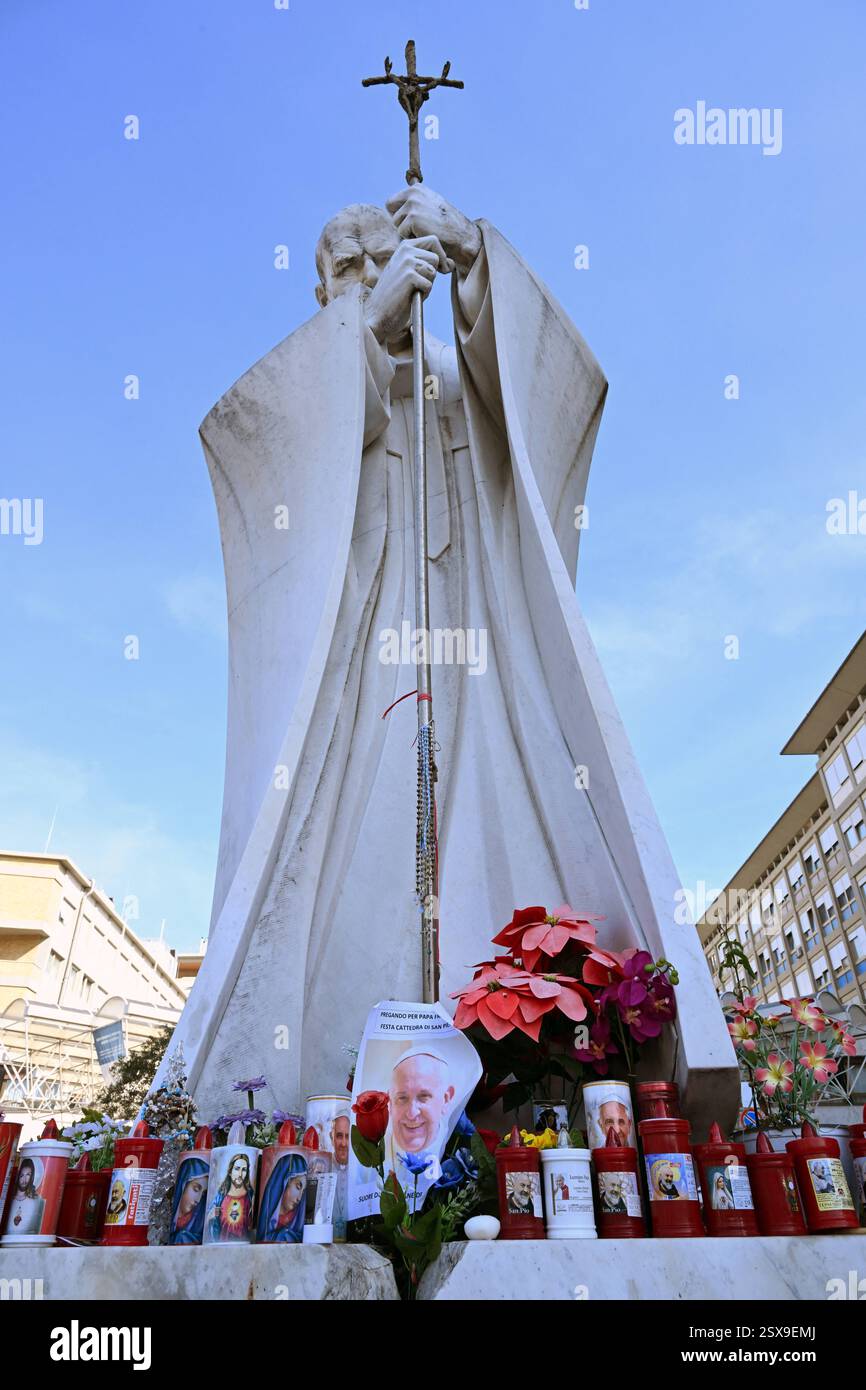 People pray near the statue of John Paul II outside the Gemelli ...
