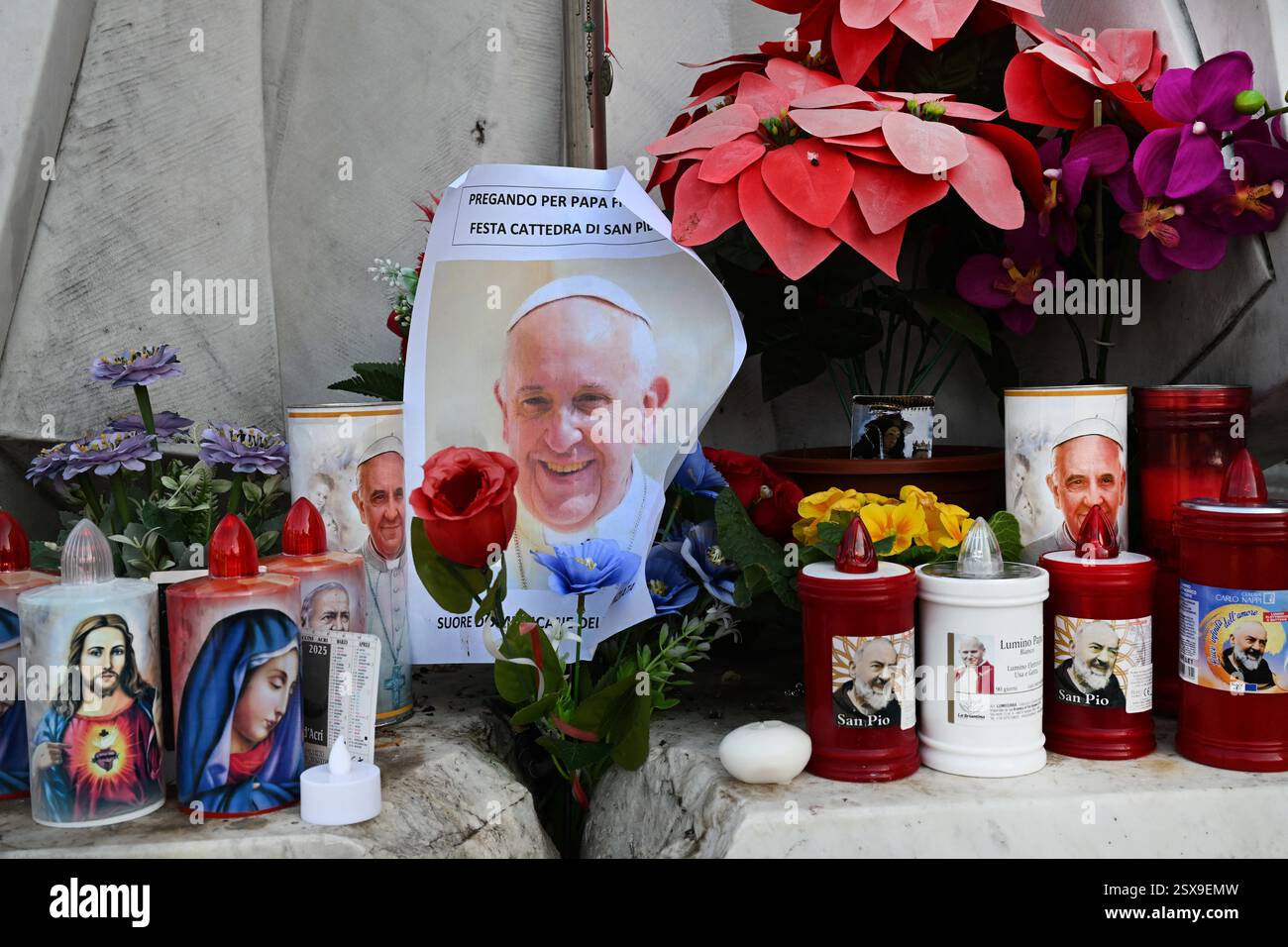 People pray near the statue of John Paul II outside the Gemelli ...