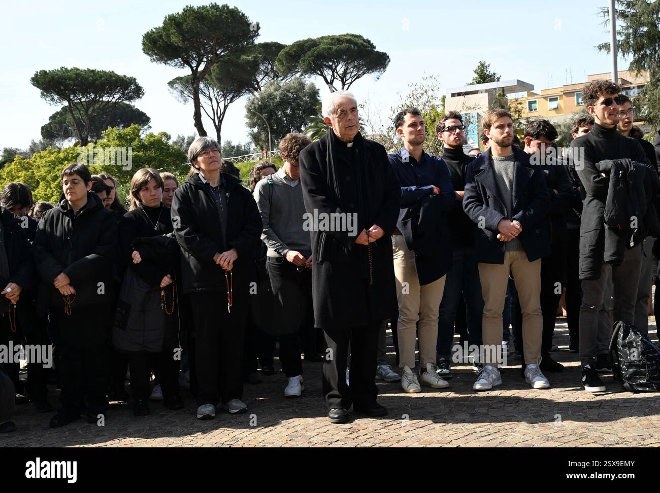 People pray near the statue of John Paul II outside the Gemelli ...