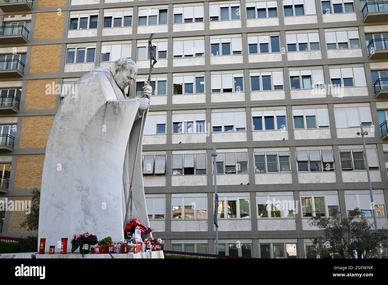 People pray near the statue of John Paul II outside the Gemelli ...