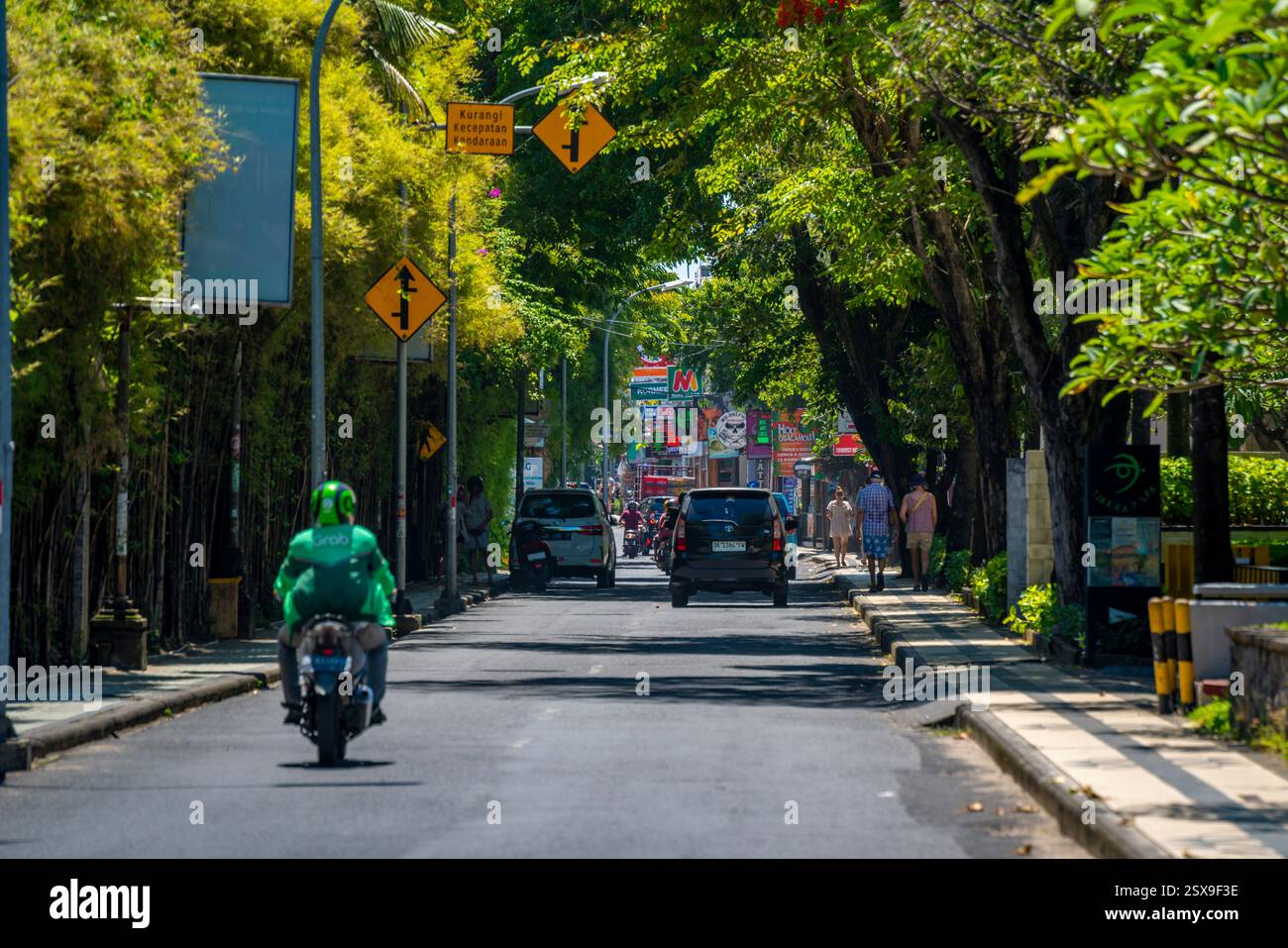 View of traffic on shady back street in Kuta, Kuta, Bali, Indonesia ...