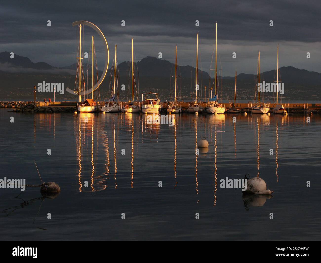 Sunset after a rainy day on lake Geneva, in Ouchy, Lausanne city's port ...