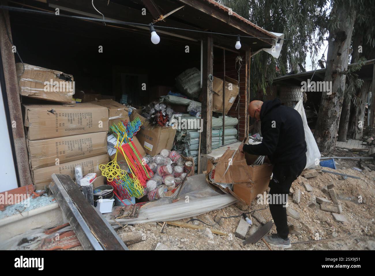 Palestinians inspect the destruction after Israeli attacks on the town ...