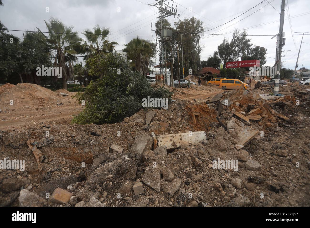 Palestinians inspect the destruction after Israeli attacks on the town ...