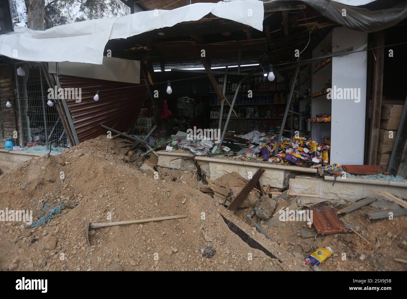 Palestinians inspect the destruction after Israeli attacks on the town ...