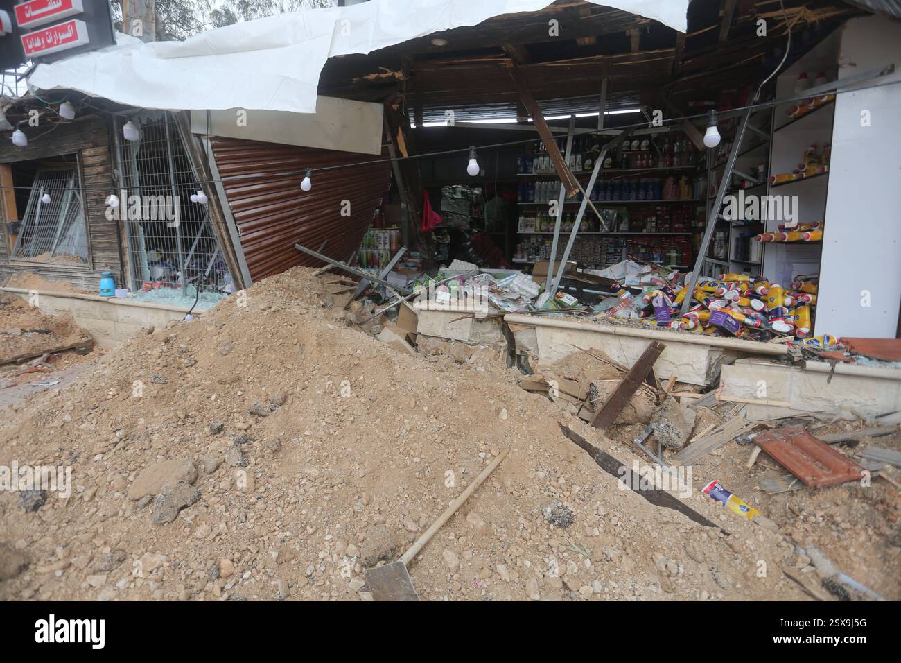 Palestinians inspect the destruction after Israeli attacks on the town ...