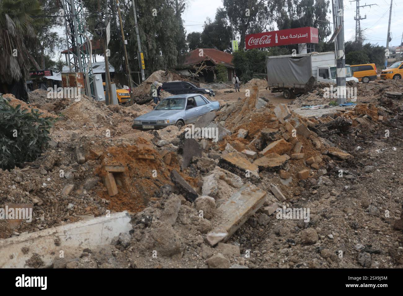 Palestinians inspect the destruction after Israeli attacks on the town ...