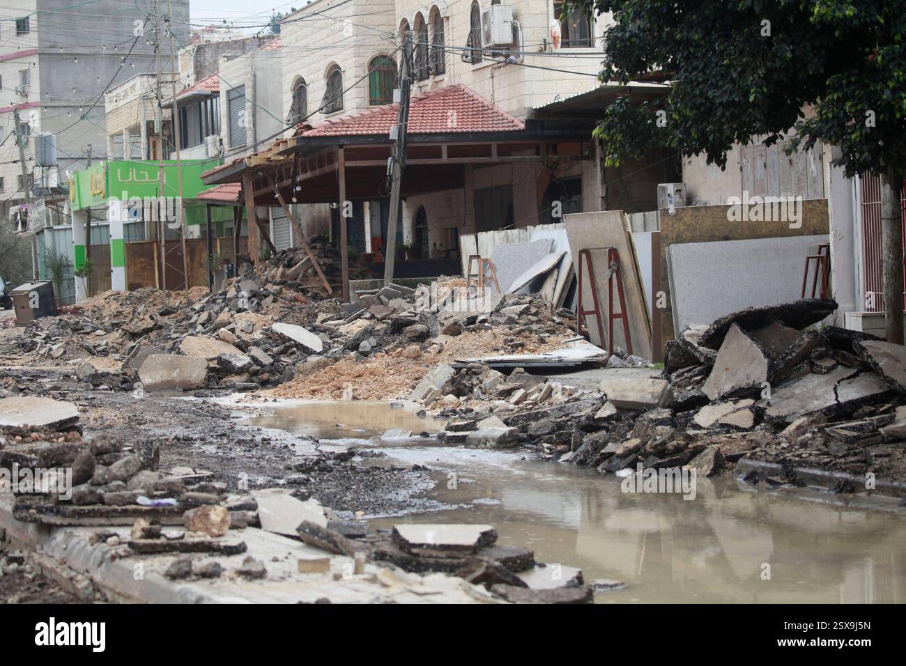 Palestinians inspect the destruction after Israeli attacks on the town ...