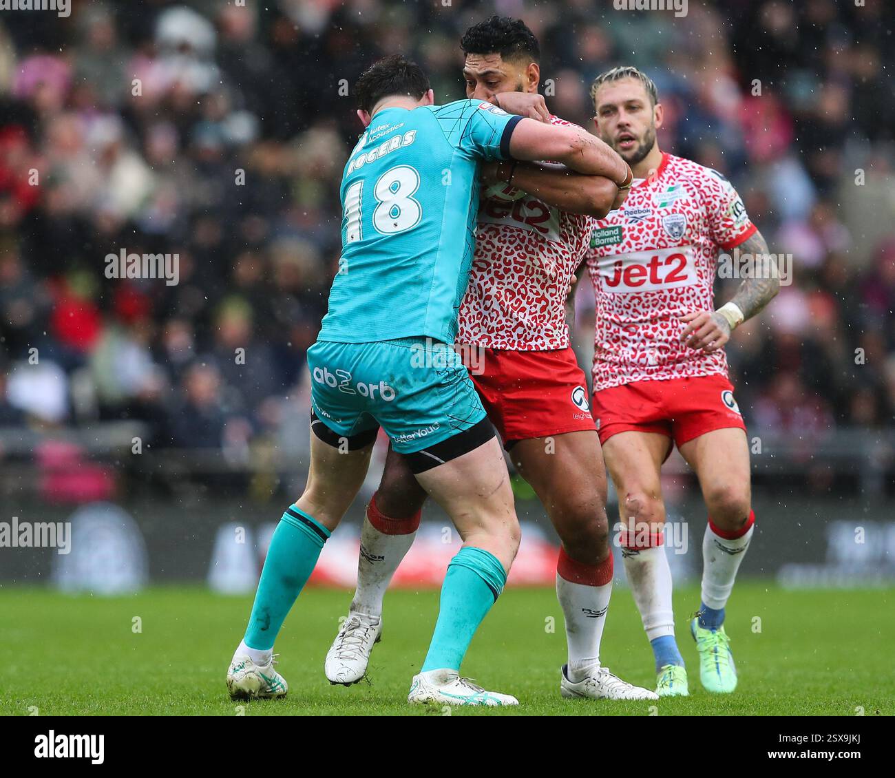 Leigh, UK. 23rd Feb, 2025. Fenton Rogers of Huddersfield Giants tackles ...