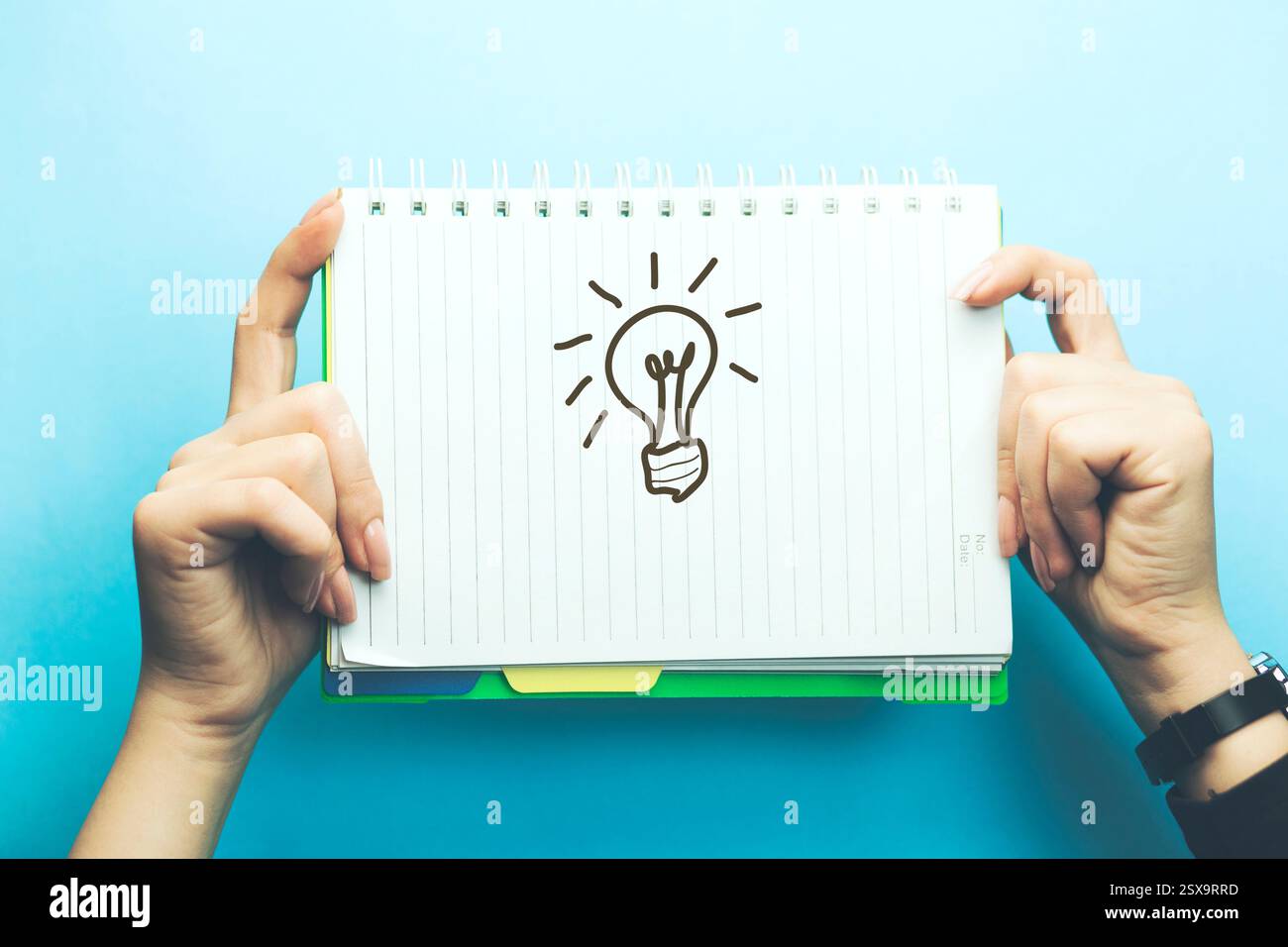 light bulb on notepad on woman hand Stock Photo - Alamy