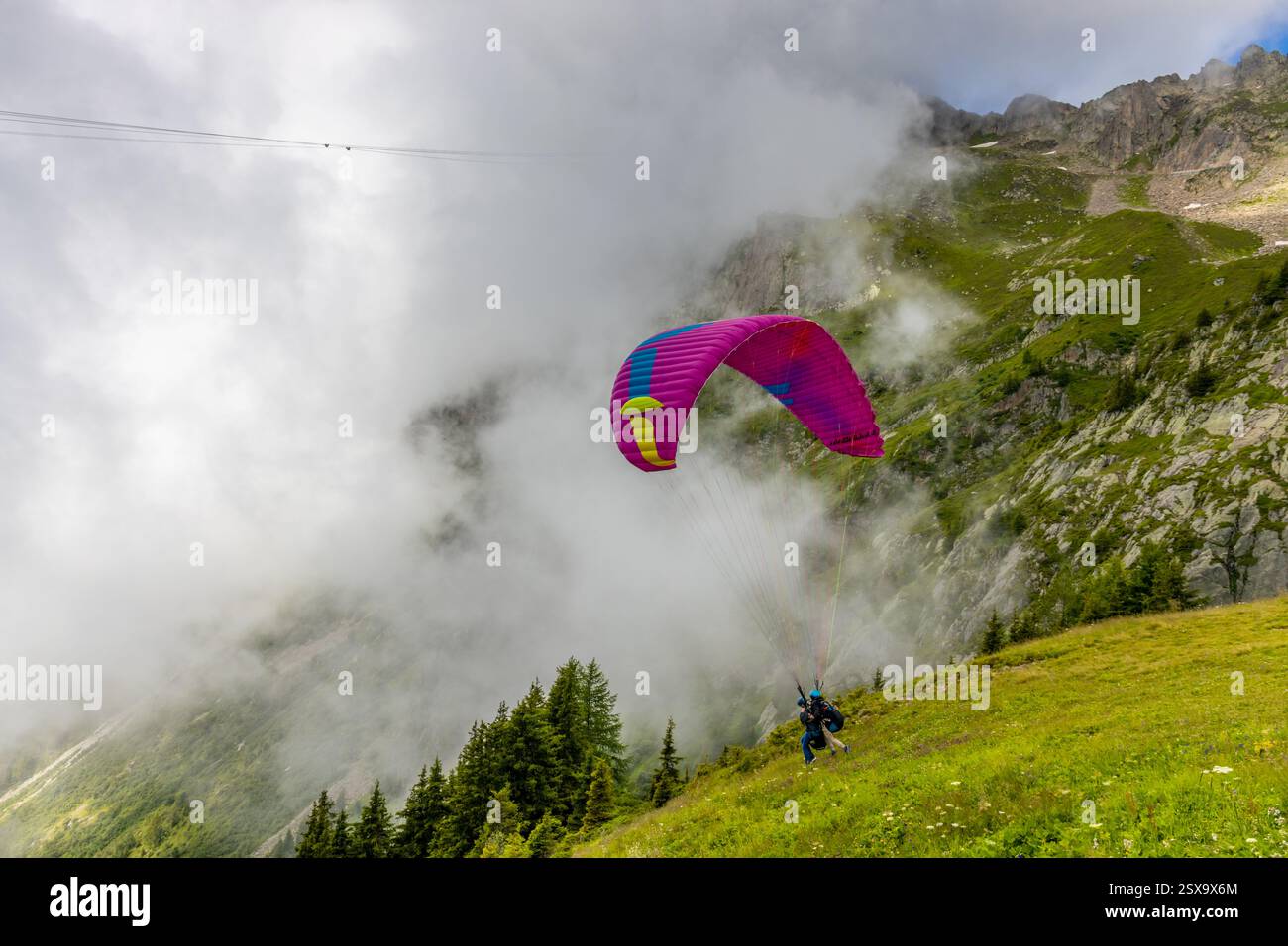 Paraglider flying in the mountains in Chamonix valley. Starting point of paragliders on Brevent ...