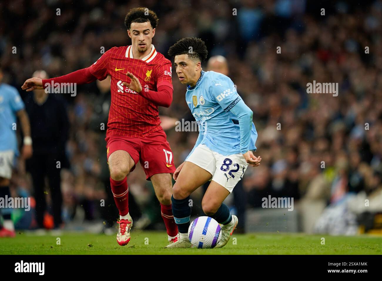 Manchester City's Rico Lewis, right, dribbles the ball past Liverpool's ...