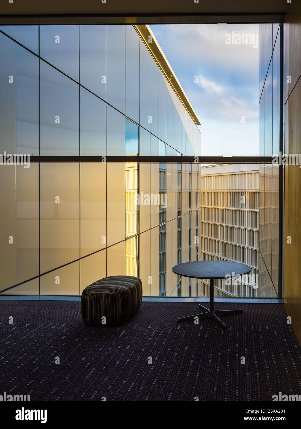 In Kastrup Denmark, a contemporary hotel lobby features expansive glass walls, allowing sunlight ...