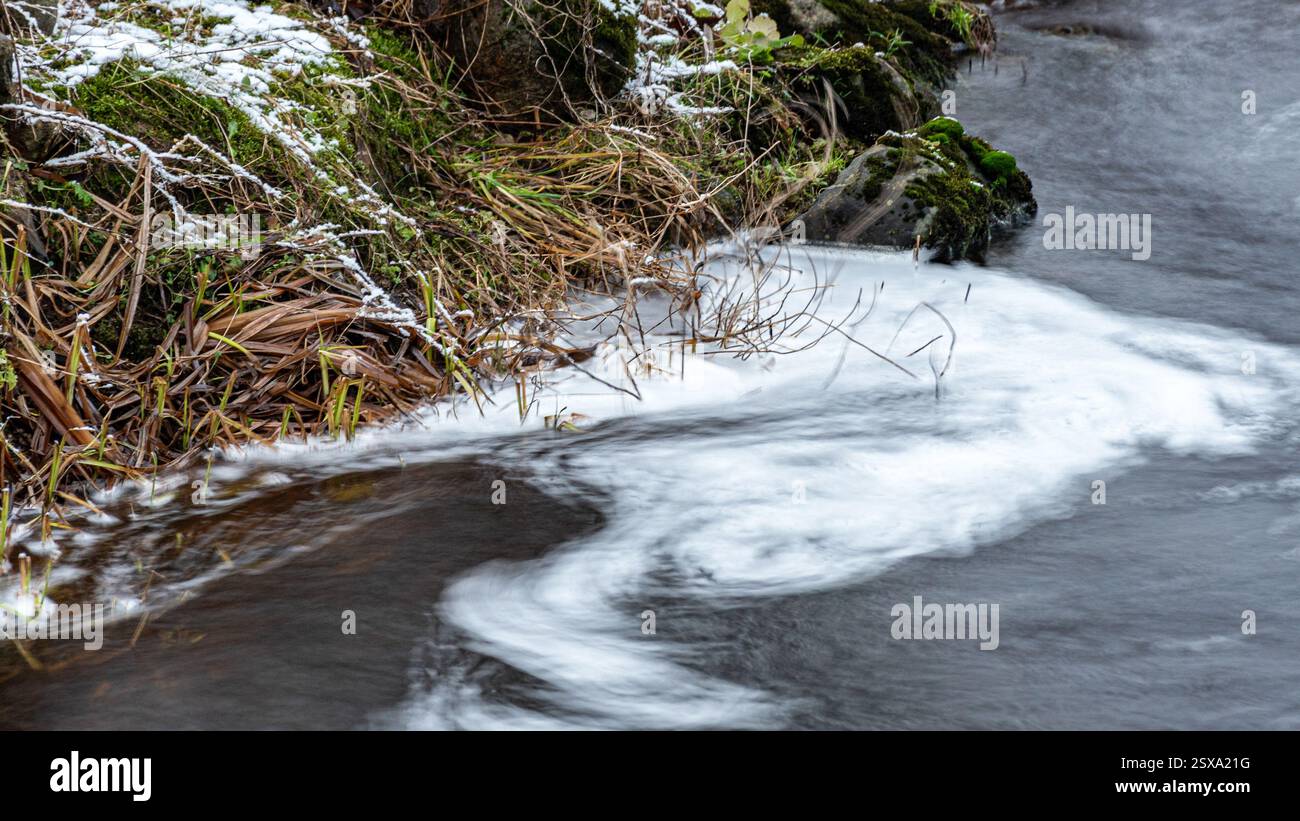 winter landscape with rapid river flow, blurred water surface, blurred ...
