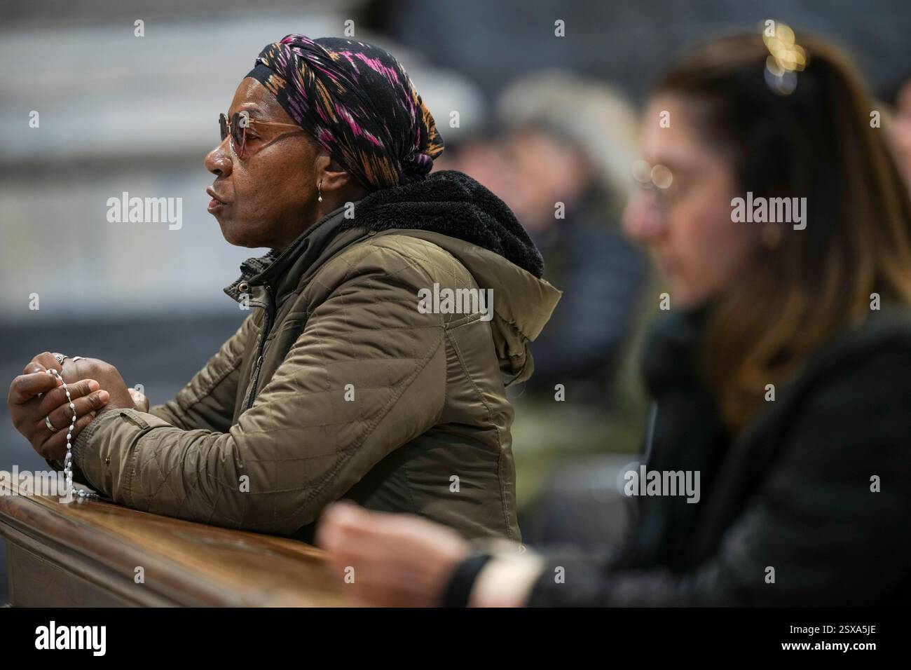 Faithful gather at St. John Lateran Basilica in Rome Sunday, Feb. 23, 2025, to pray for Pope ...