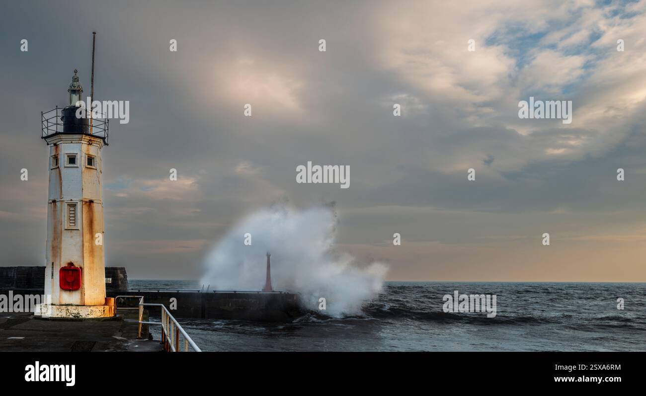 Waves crash over the breakwater near the old lighthouse at Anstruther ...