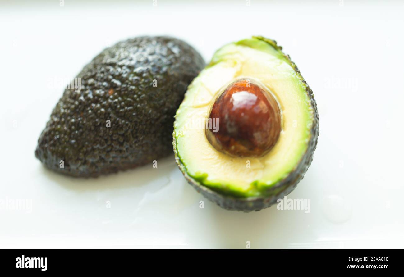 Close-up of a single avocado cut in half with the seed stone shown at ...