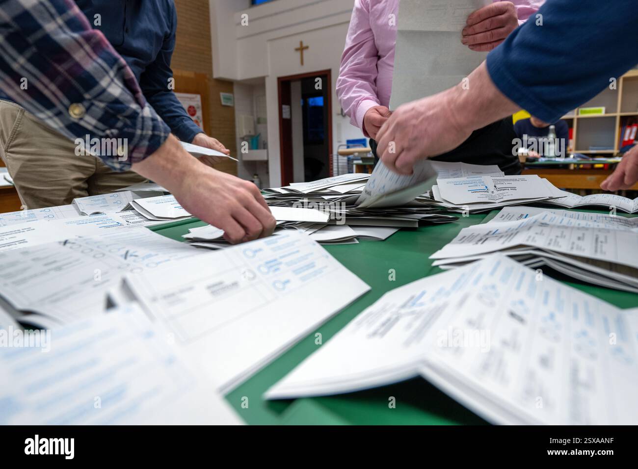 23 February 2025, Bavaria, Untermerzbach: Election workers sort ballot ...